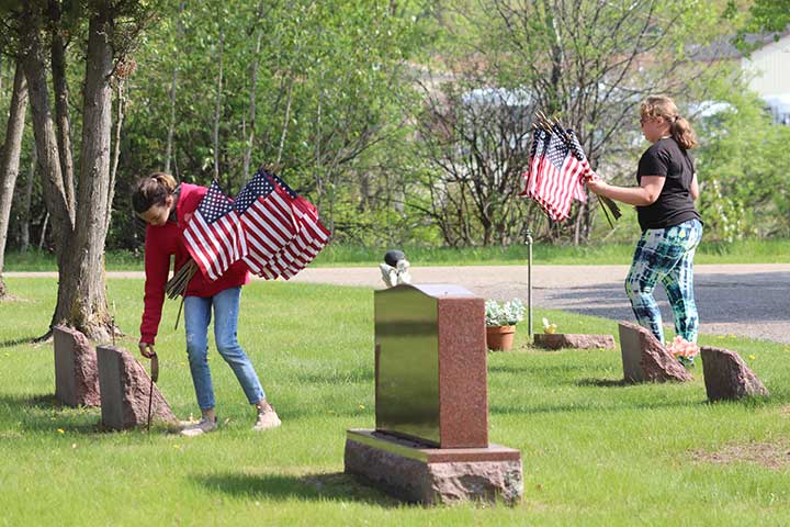 Area fifth-graders place flags at graves to honor buried veterans ...